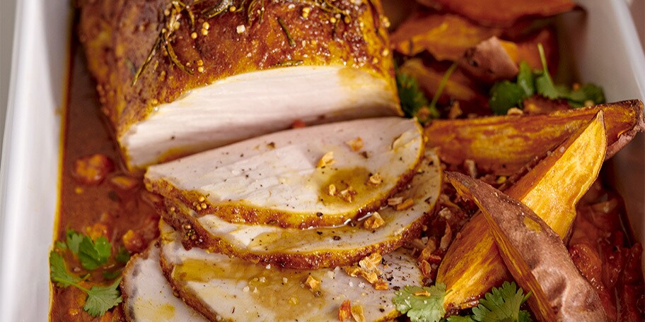 Varkensgebraad met kruiden, kokosmelksaus en zoete ardappelen uit de oven